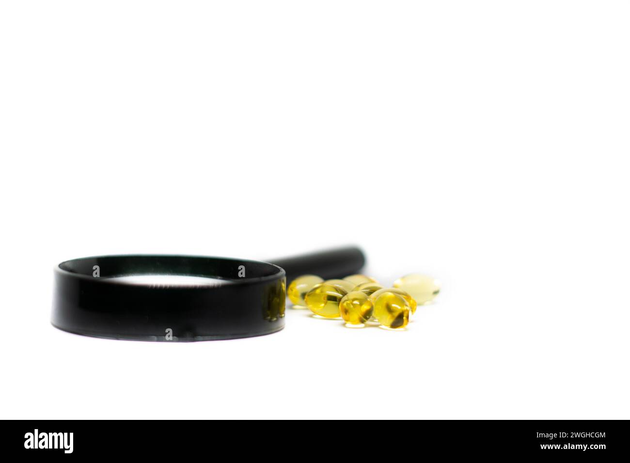 Yellow omega-3 capsules in a plastic bottle on a white background ...