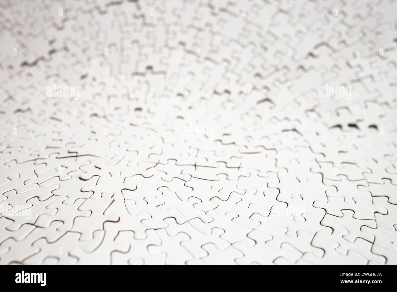 Plain white radial jigsaw puzzle defocused, abstract texture close up ...