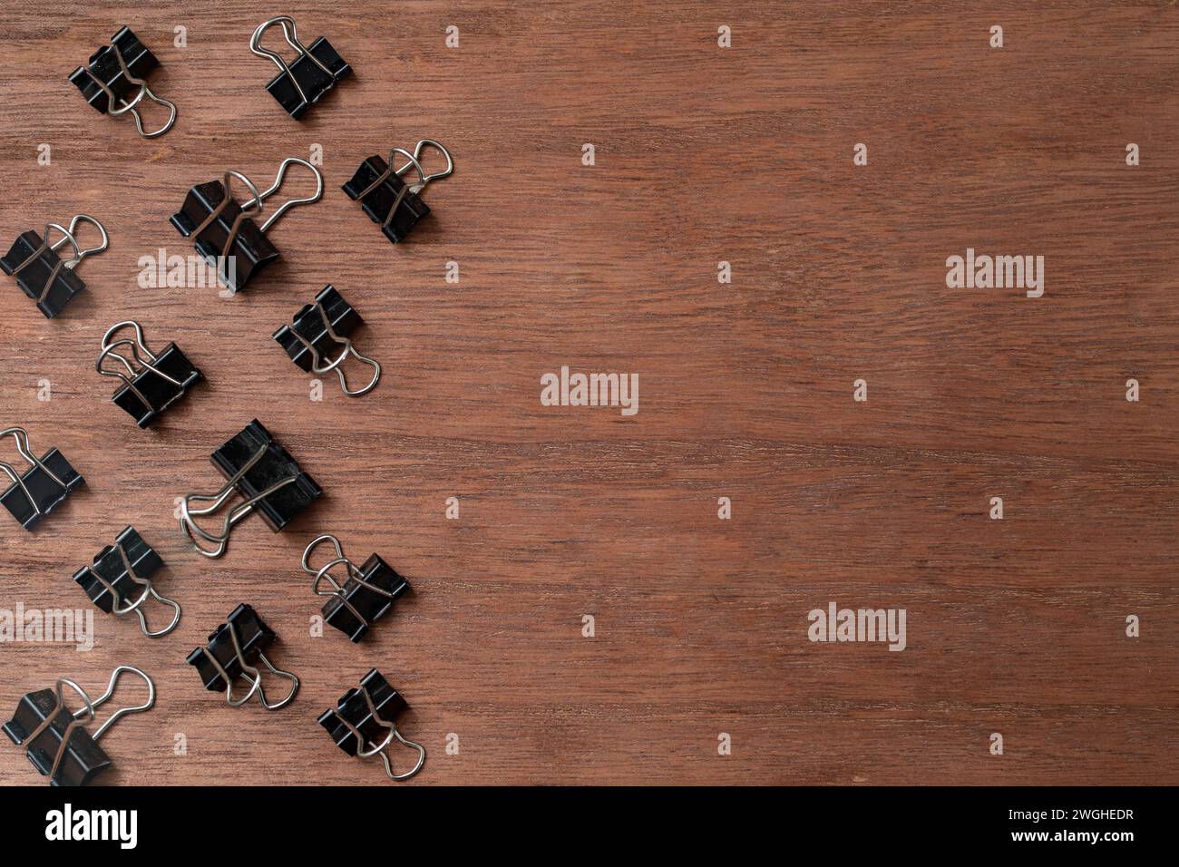 Metal black binder clips wooden background. Paper clips tool for paper ...