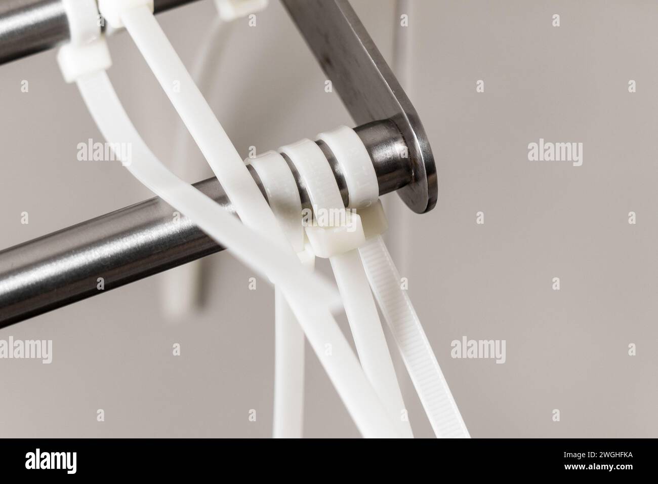 Fixed plastic cable ties on a steel structure close up Stock Photo - Alamy