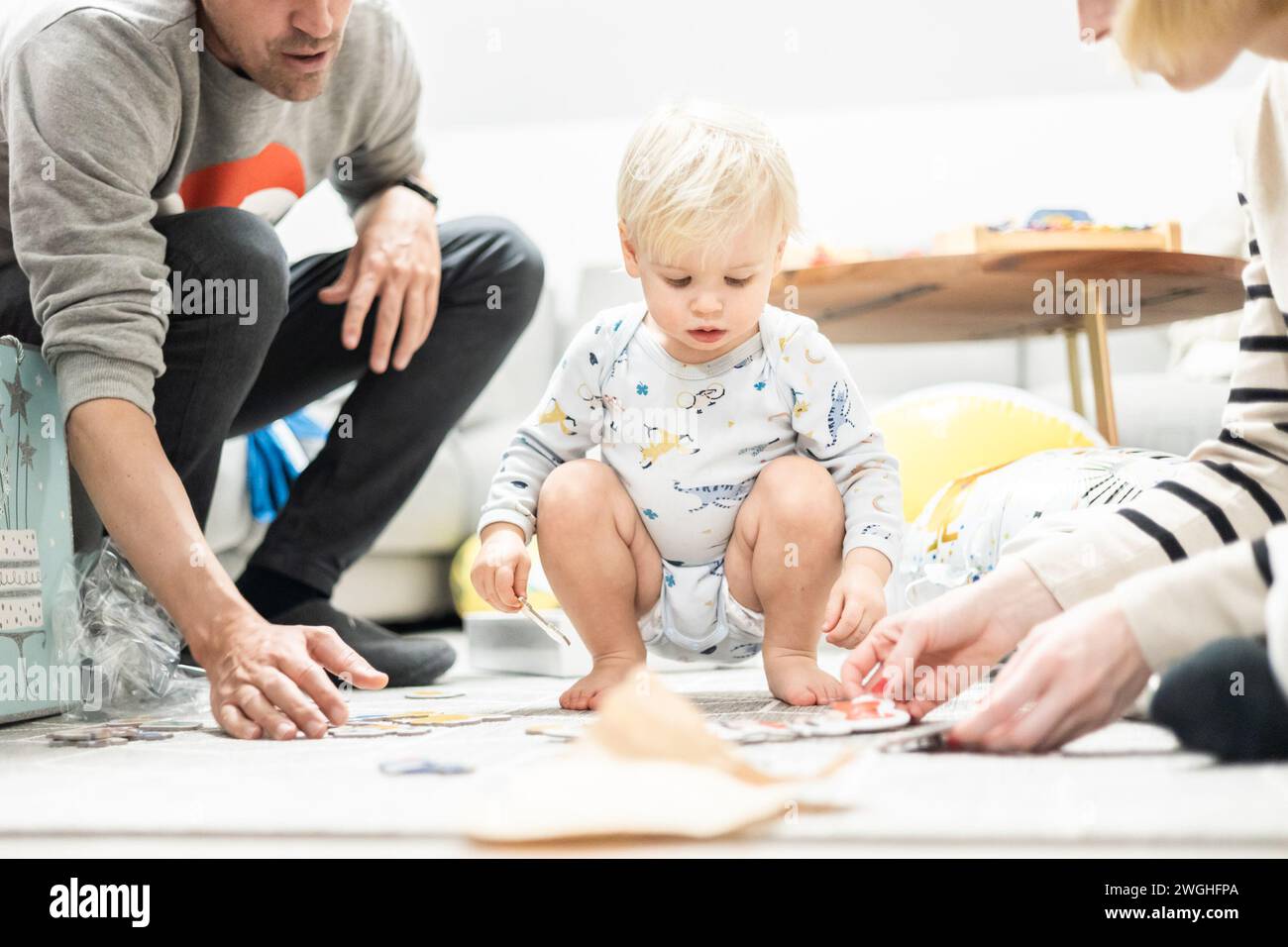Parents playing games with child. Little toddler doing puzzle. Infant ...