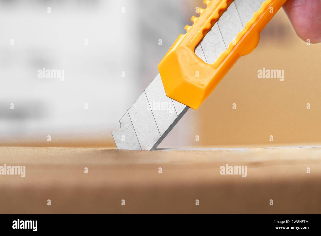 Cutting a cardboard postal gift box to open the parcel with a utility ...