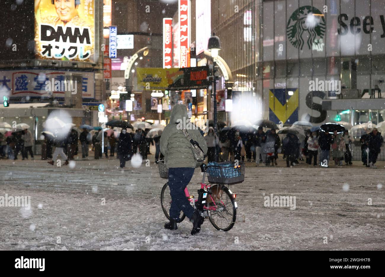 People walk in the snow near Shibuya Station in Tokyo on Feb. 5, 2024 ...
