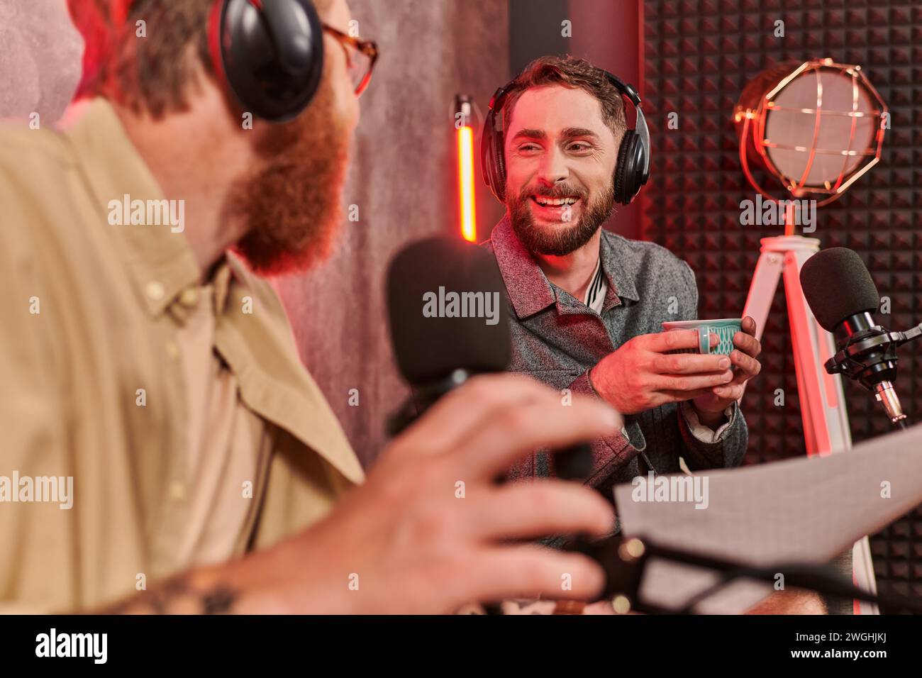 two bearded handsome men in casual attires with headphones talking ...