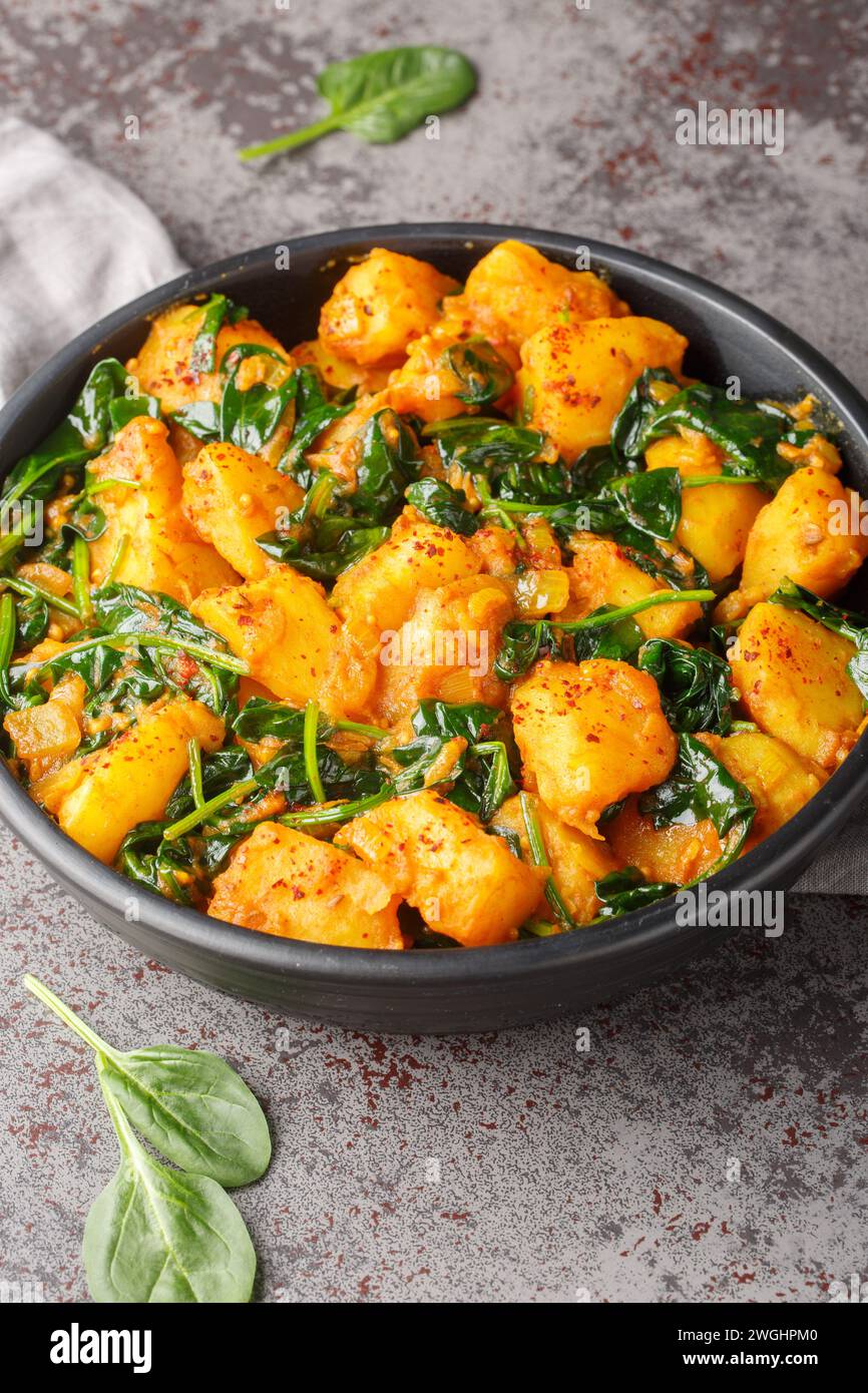 Spiced curry dish made with potatoes and spinach saag aloo closeup on ...
