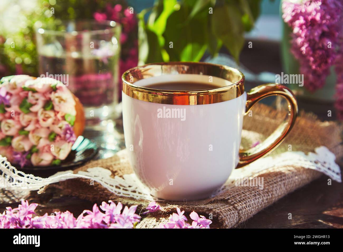 Coffee break with cup of coffee among lilac flowers. Floral creative ...
