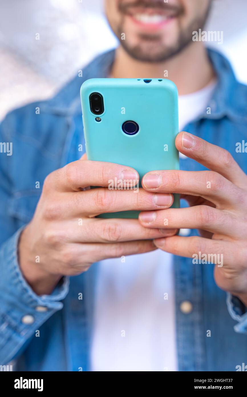 Vertical close-up unrecognizable Smiling young man using an app on his ...