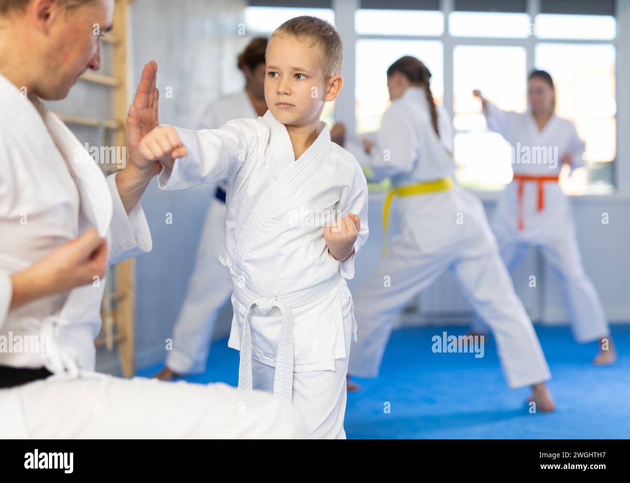 Boy is paired with man teacher to learn how to strike and rehearses ...