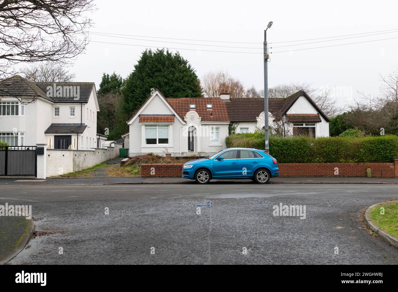suburban landscape with front yard and blue car parked in front of it ...