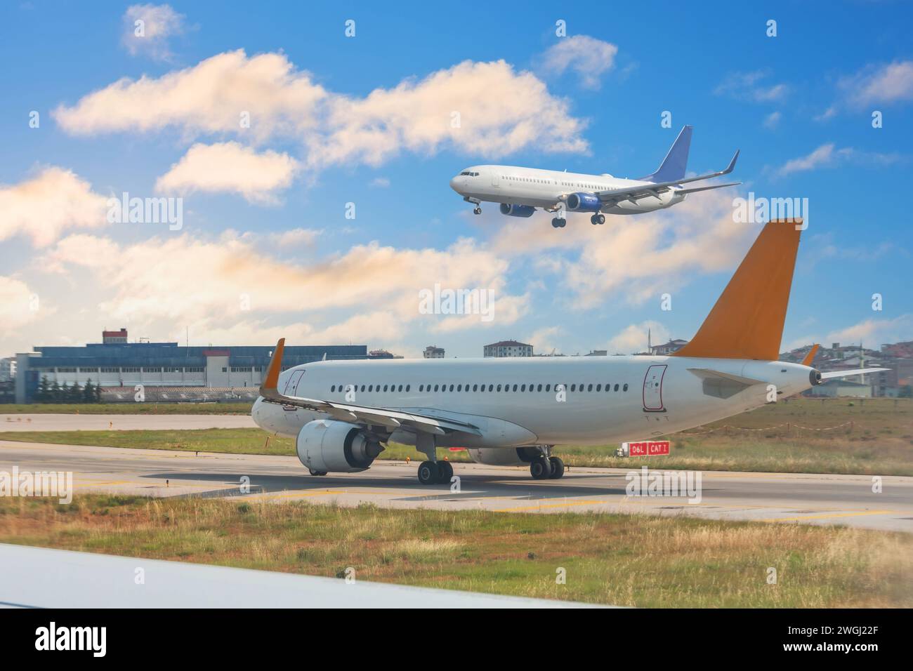 Aircraft is waiting take off, another one lands on the runway. Airport ...