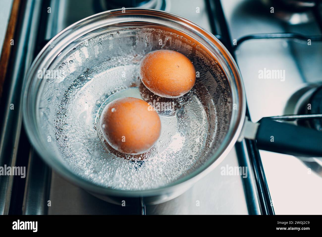 Saucepan stainless steel with two boiling eggs breakfast in a water on ...