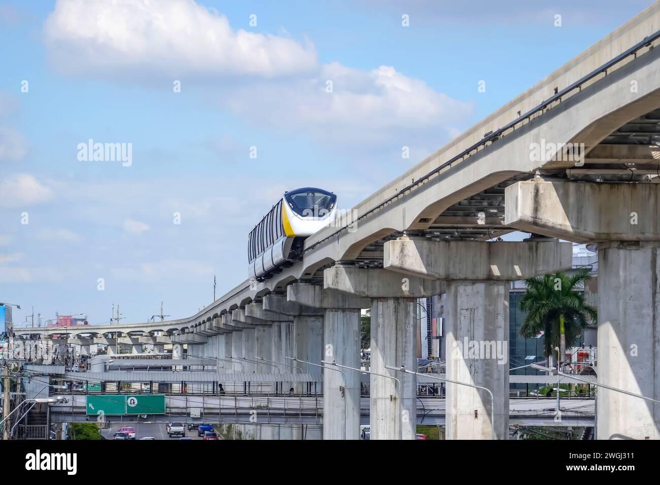 Modern speed monorail train passes along the high supports of viaduct ...
