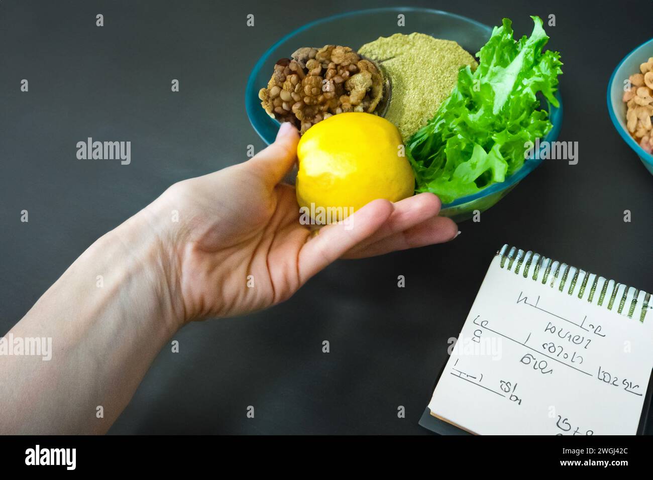 Intermittent fasting. Apple in hand and healthy food on a plate with ...