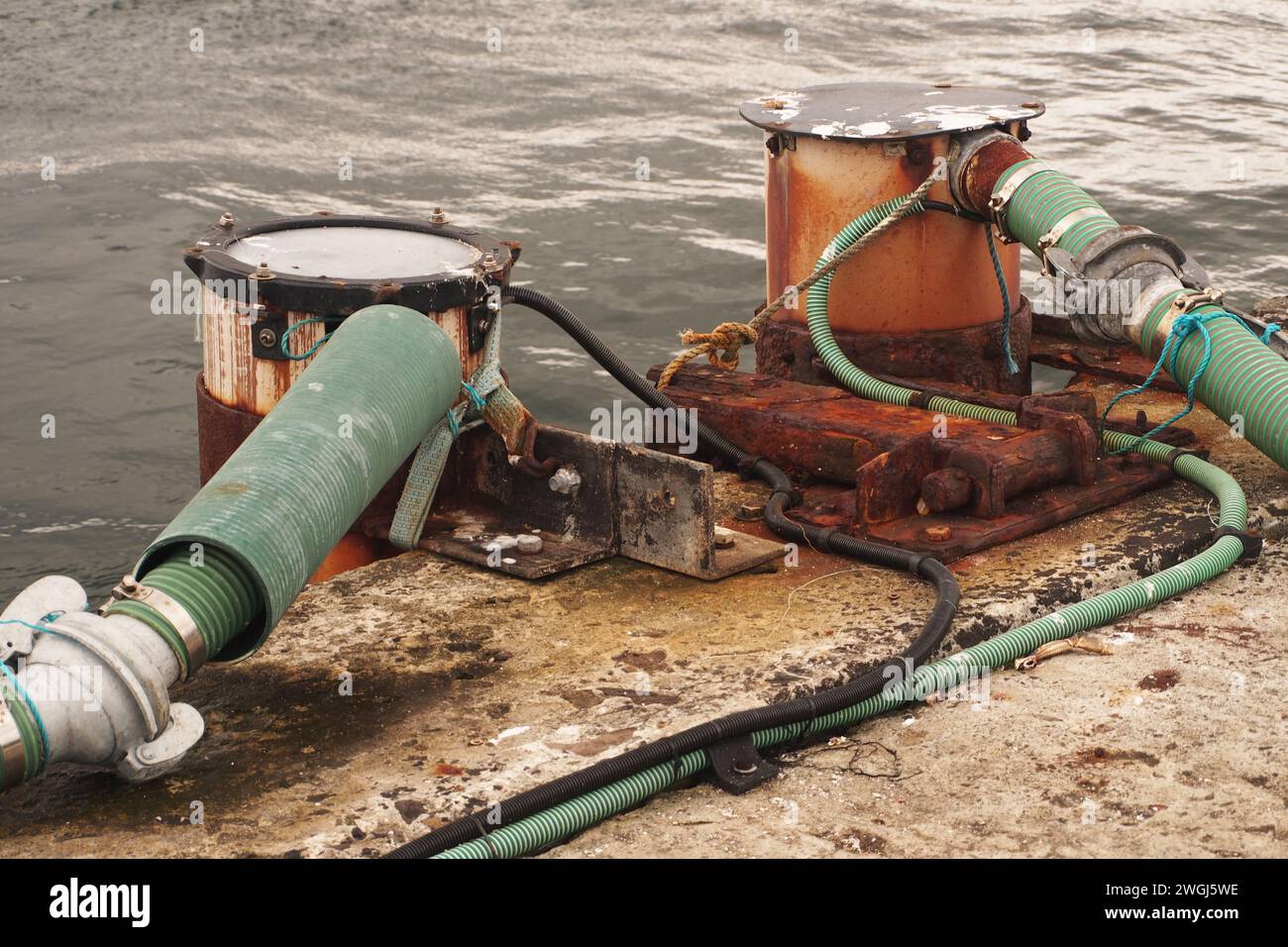 Inlet and outlet water pipes on a small seaside pier, Orkney Stock ...