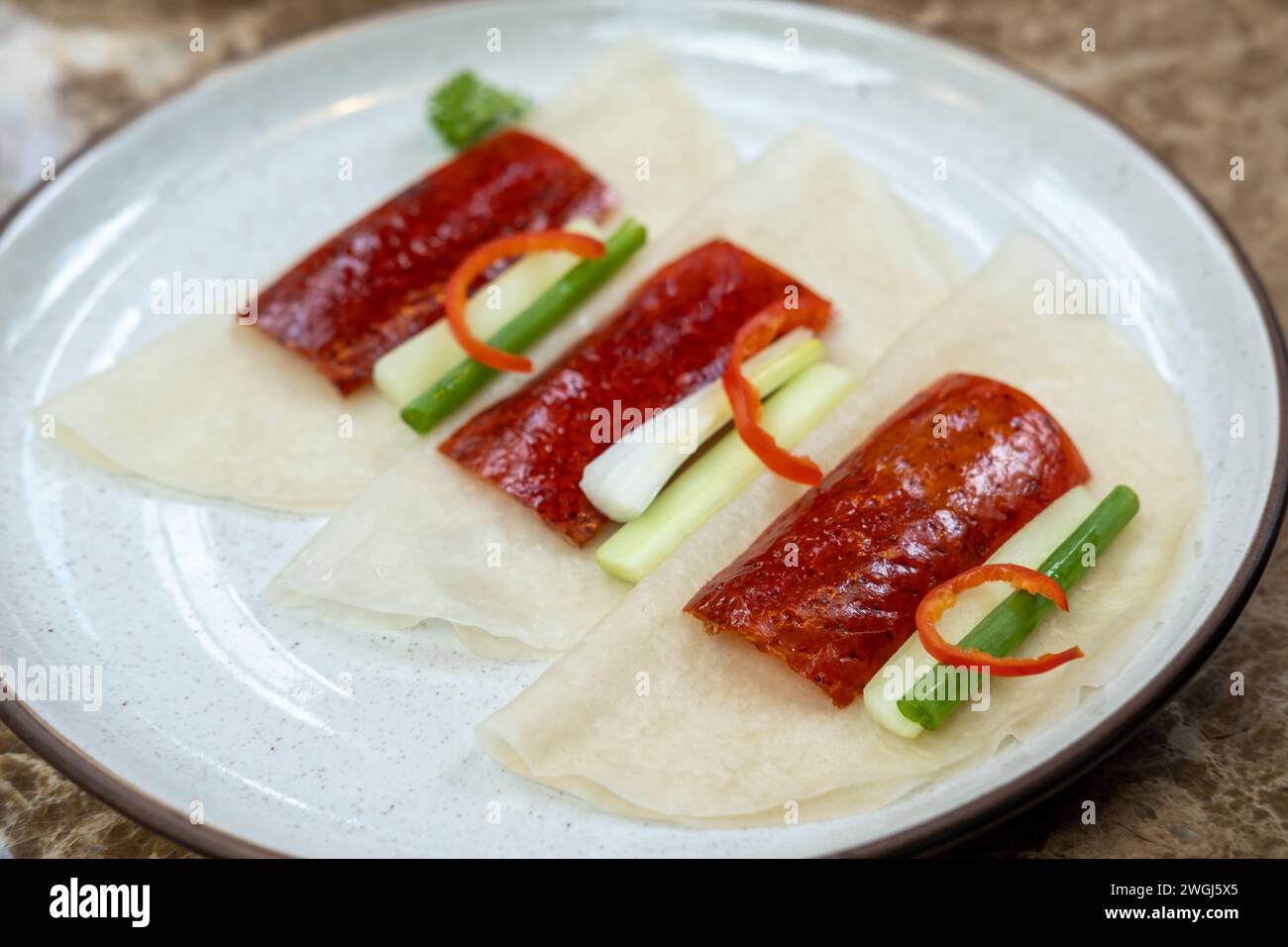 Deep fried Peking duck skin, served on plate Stock Photo - Alamy