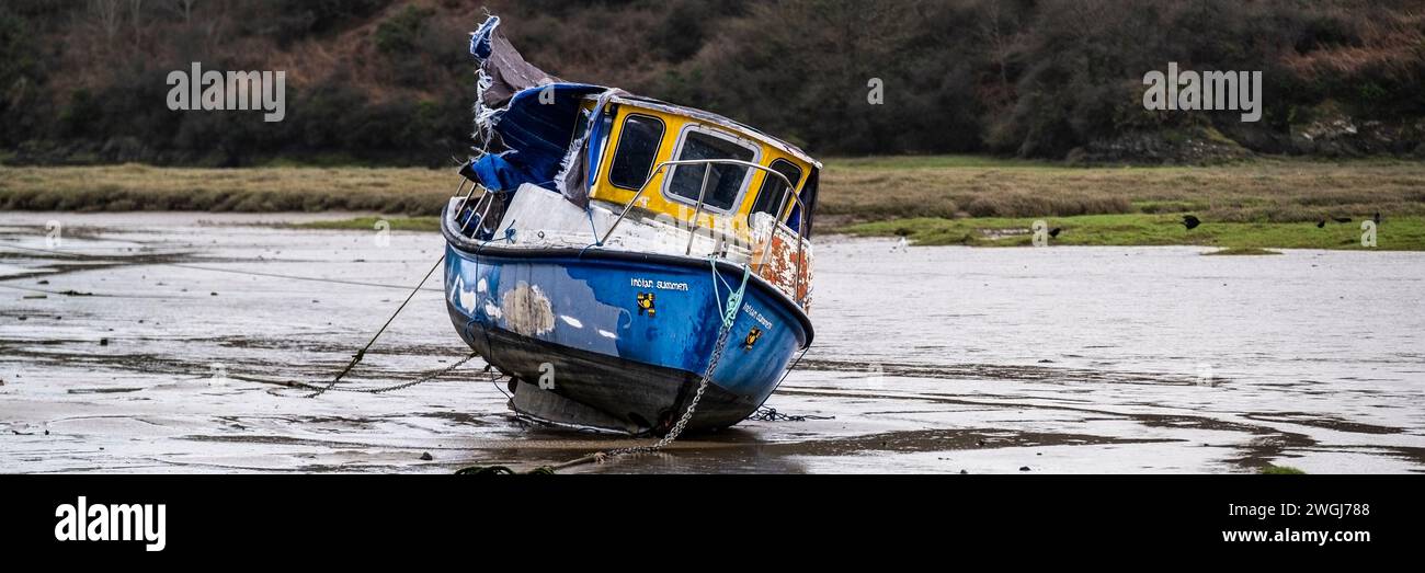 A panoramic image of a boat being restored and moored at low tide on ...