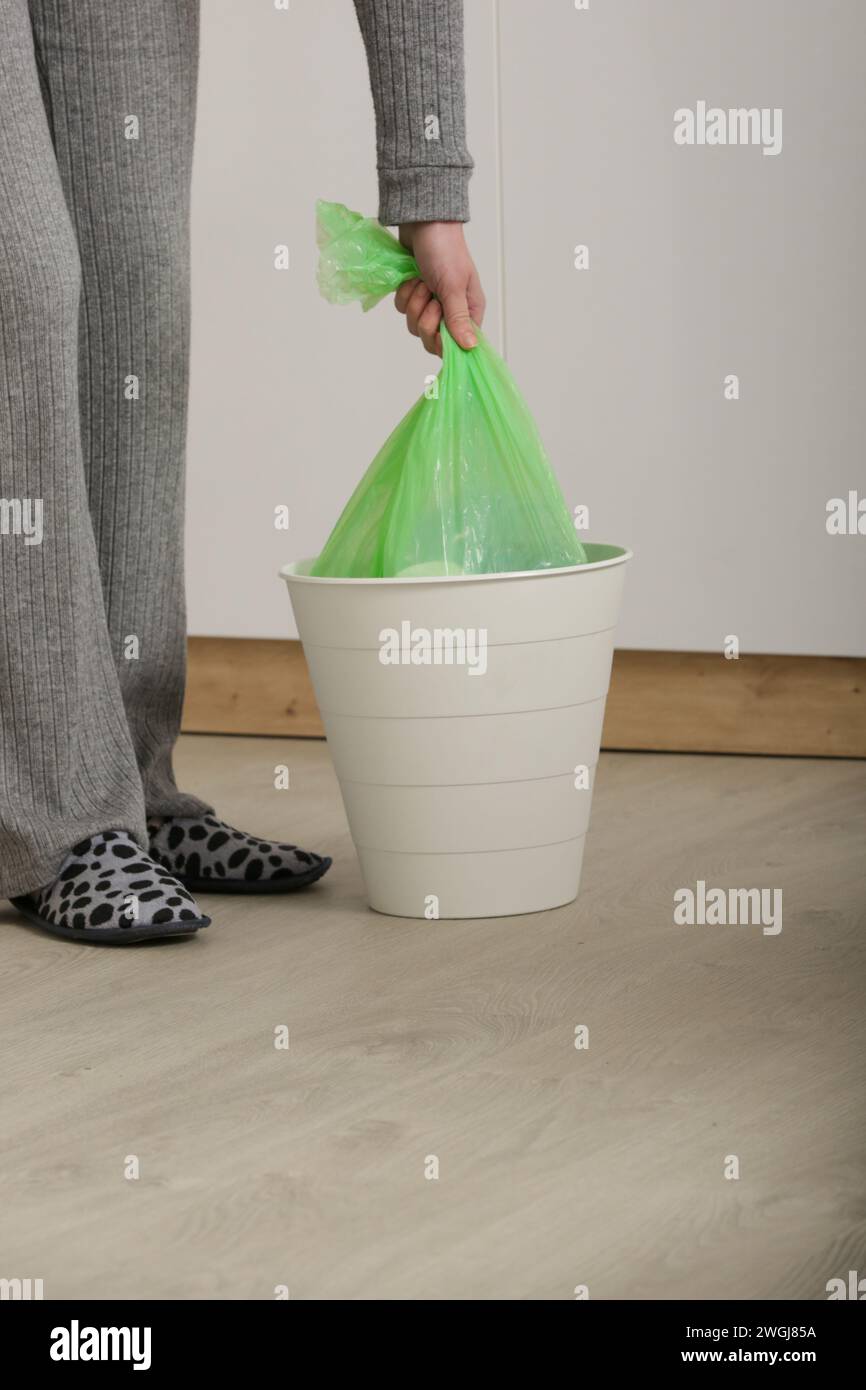 Housewife throwing away garbage, taking of plastic garbage bag from the ...