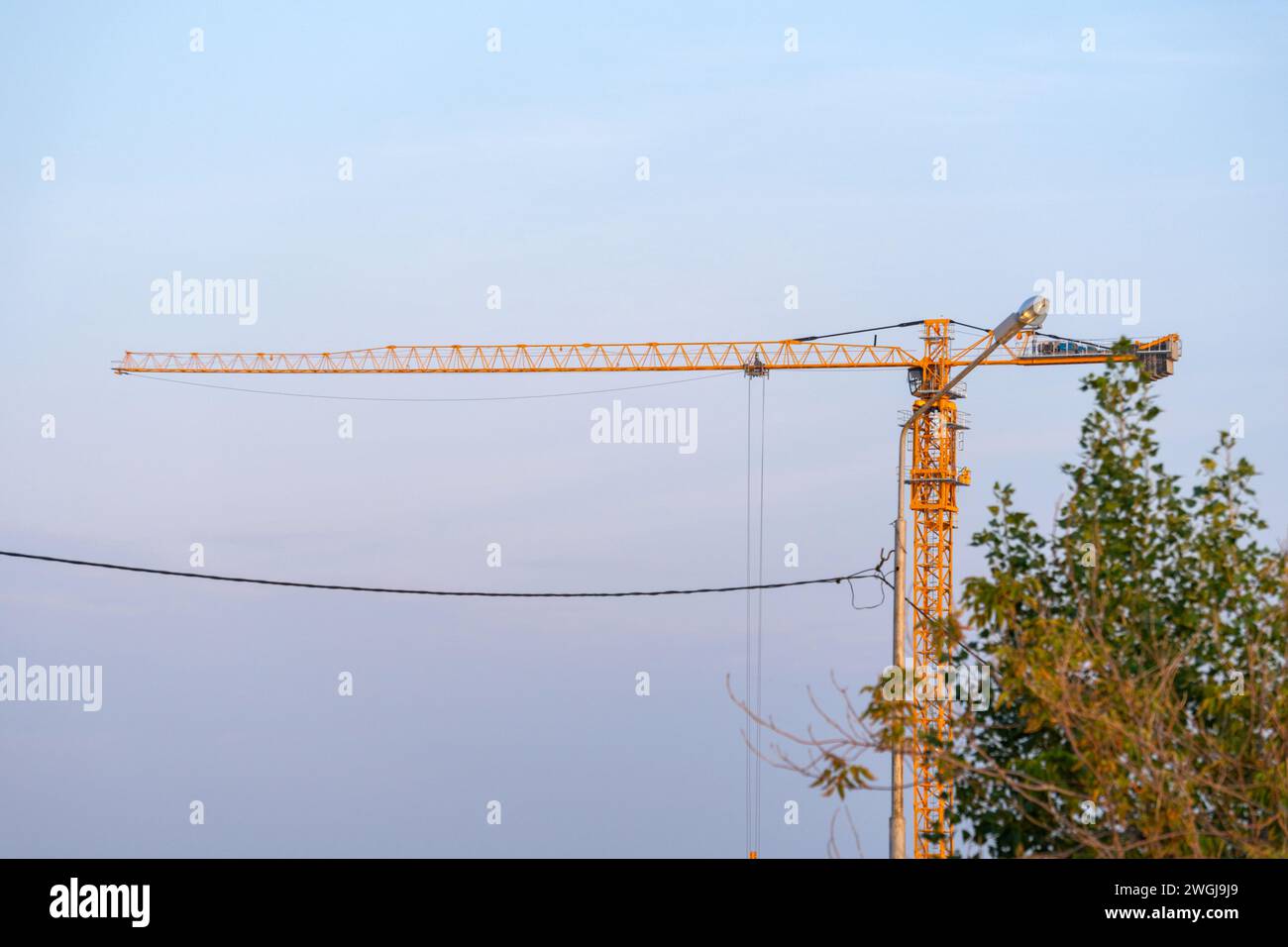 Construction crane stands tall and poised atop a power line in the ...