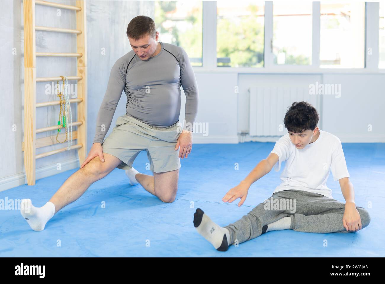 Father and son train muscles and stretching in gym Stock Photo - Alamy