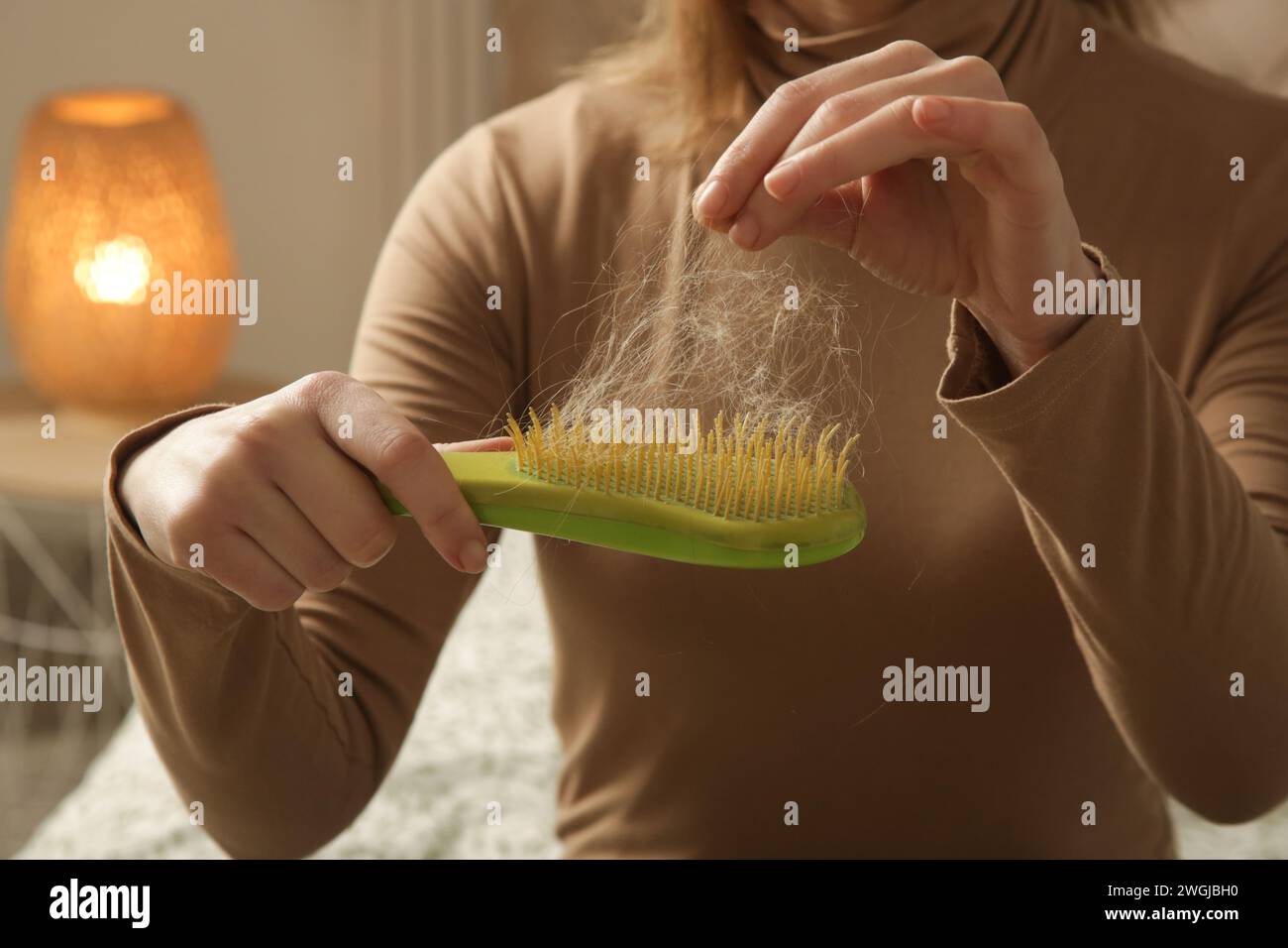 Woman holding detangler hair brush full of hair that has fallen out ...