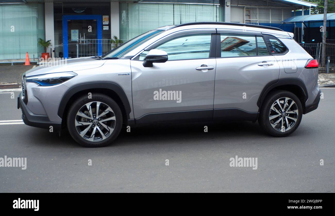 Silver SUV car, Toyota Corolla Cross V HS, driving in commercial area ...