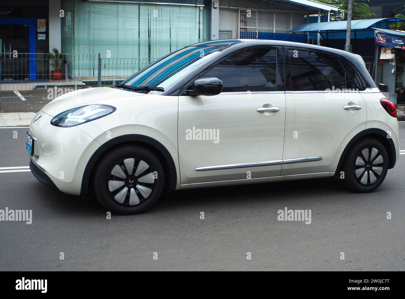 White Wuling Binguo EV car, driving in commercial area, Radio Dalam ...