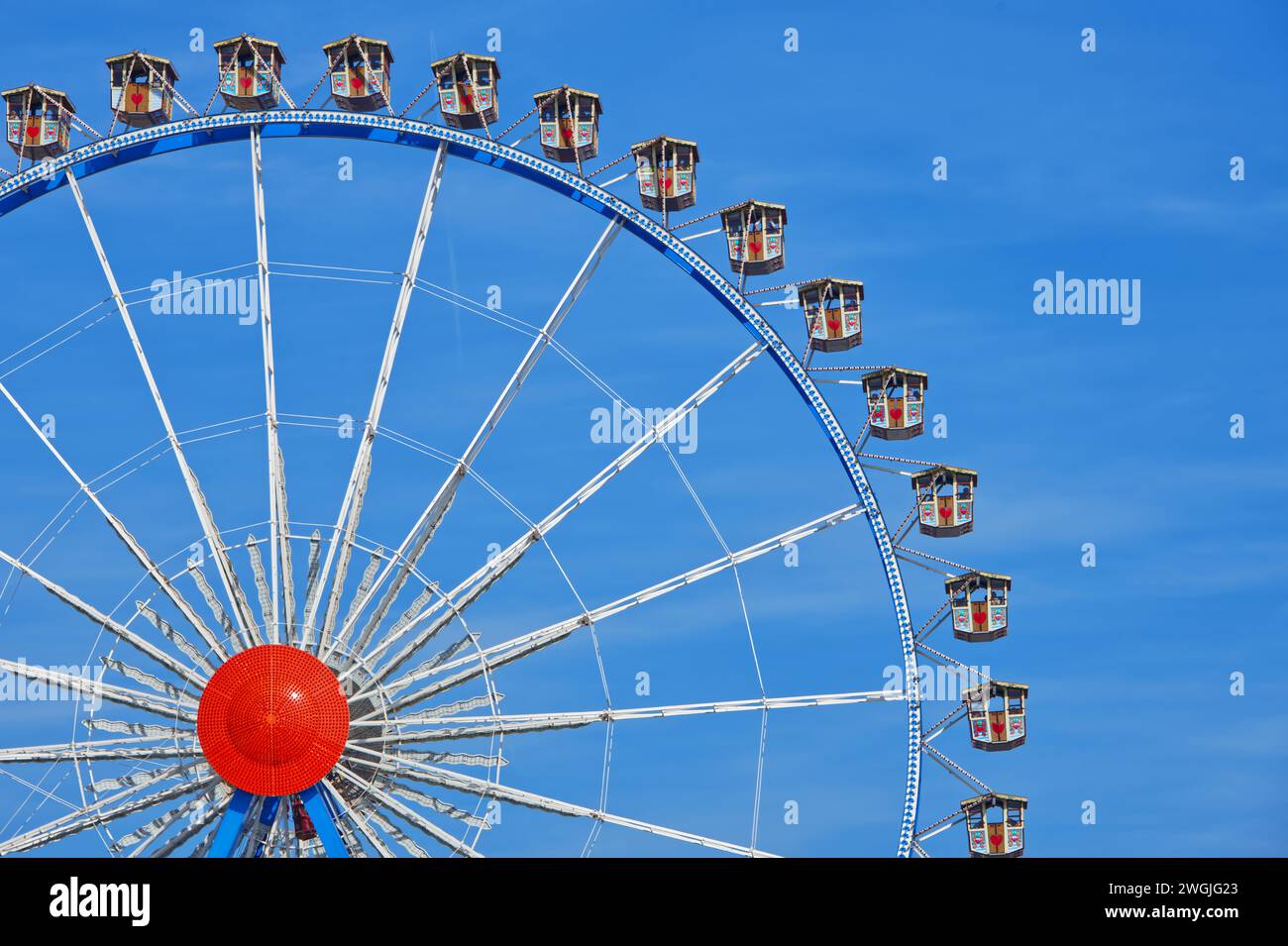 Part of a ferris wheel with many decorated colorful gondolas rotating ...
