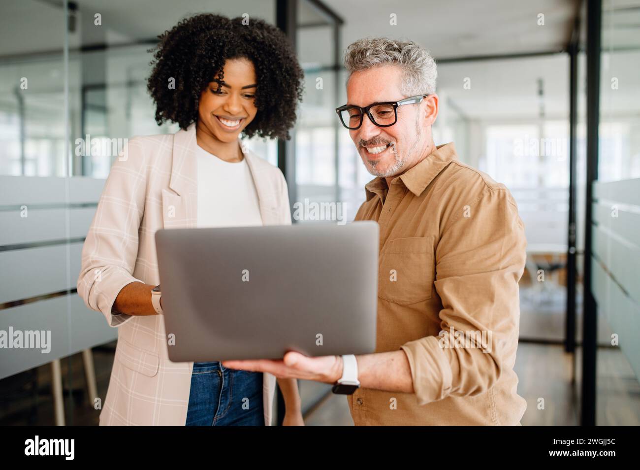 Black businesswoman and her senior male colleague engage warmly with a ...