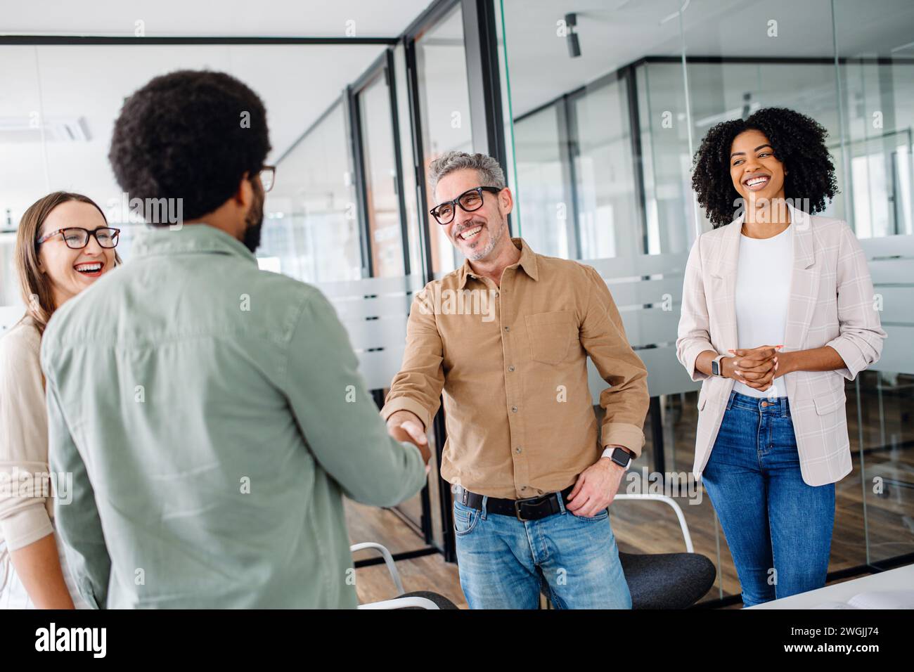 A friendly office environment is depicted where a team greets each ...