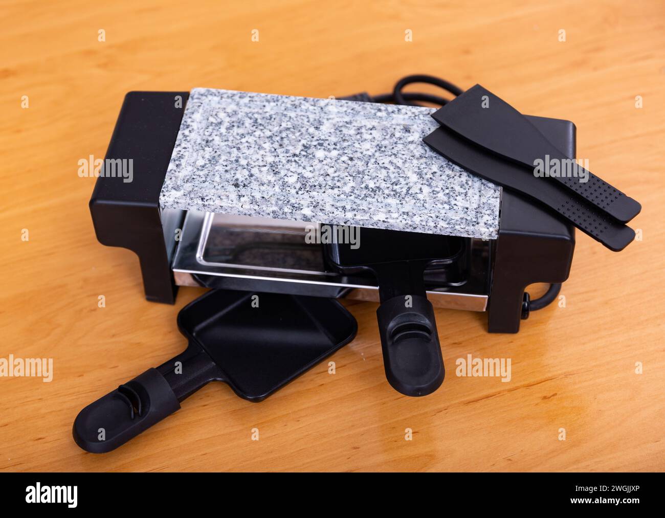 Table-top grill involved in serving swiss dish of raclette Stock Photo ...