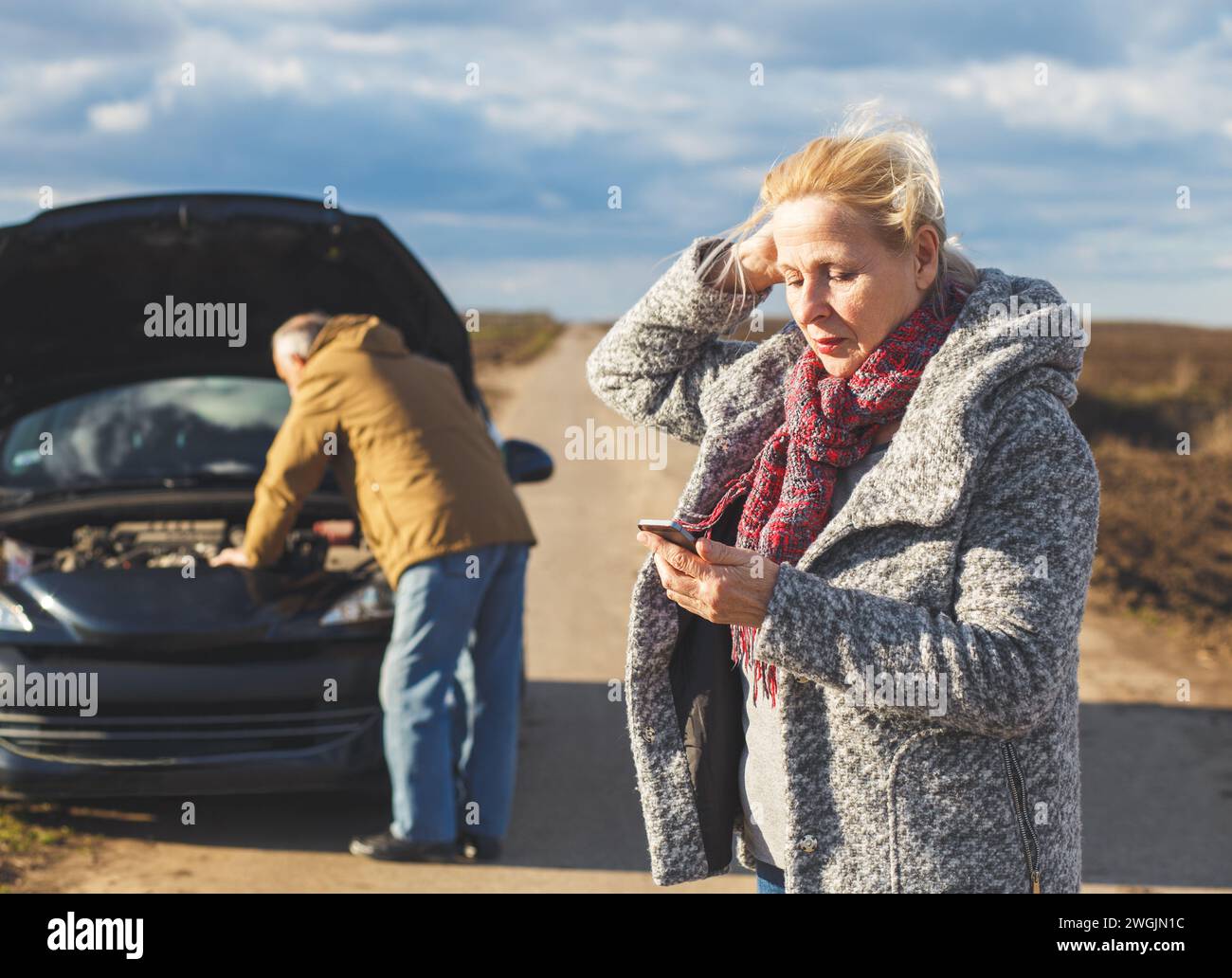 Senior woman on the road having engine failure, she is calling for ...