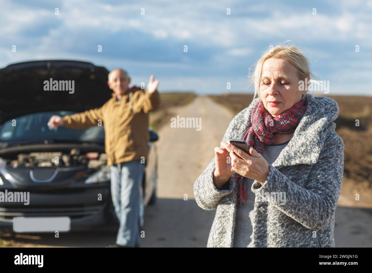 Senior woman on the road having engine failure, she is calling for ...