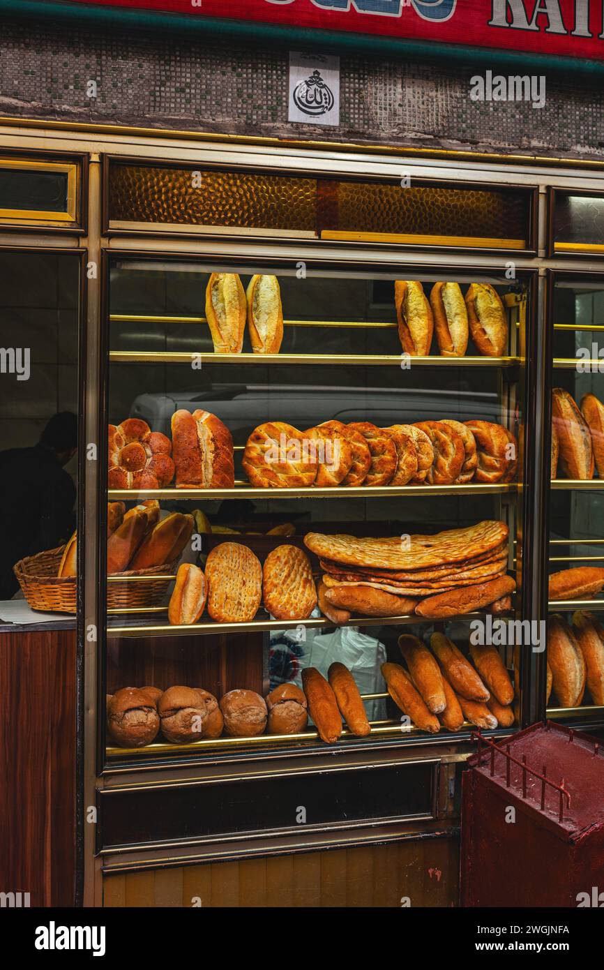 A glass display case showcasing an assortment of fresh bread and rolls ...