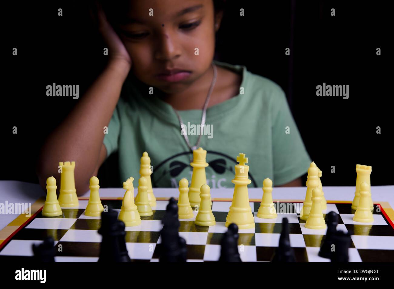 A captivating portrait of a young girl, deeply concentrated on her next ...