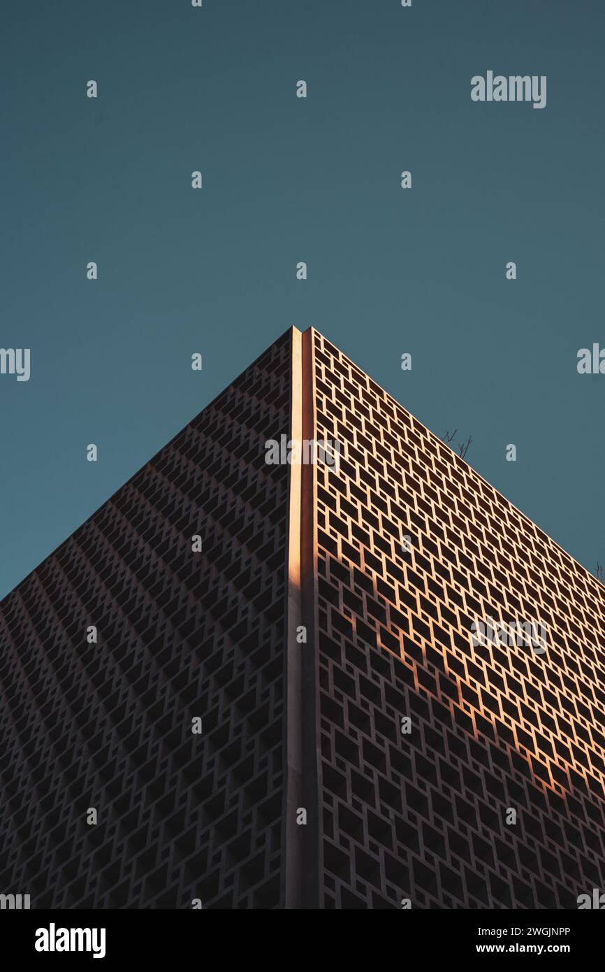 Morning sun shines on a high-rise building against a clear blue sky in ...