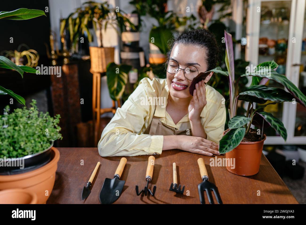 Happy successful woman florist in her flower shop enjoy surrounded with ...