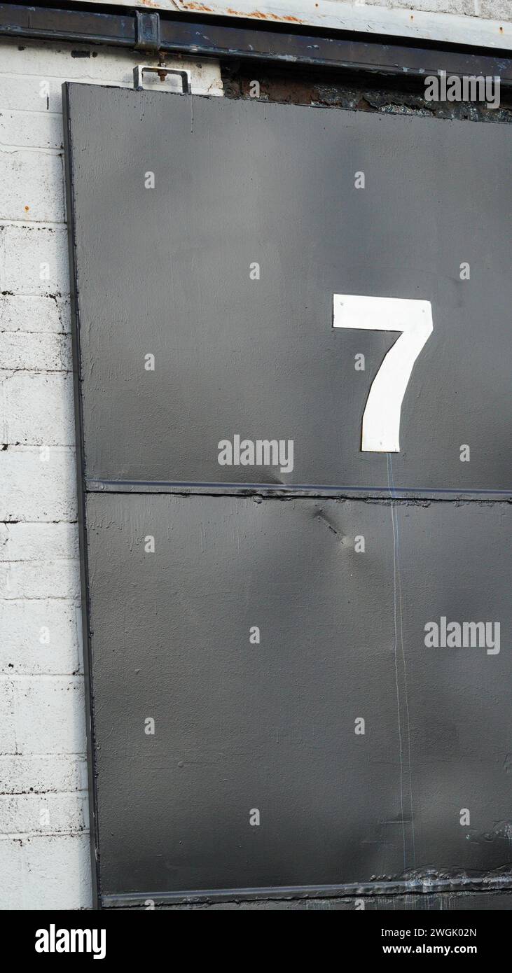 Black door with white number 7 on an industrial unit Stock Photo - Alamy