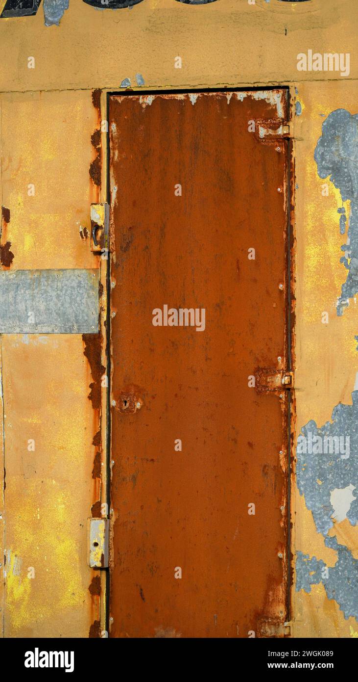 Large brightly painted yellow door on a lock-up in an industrial ...