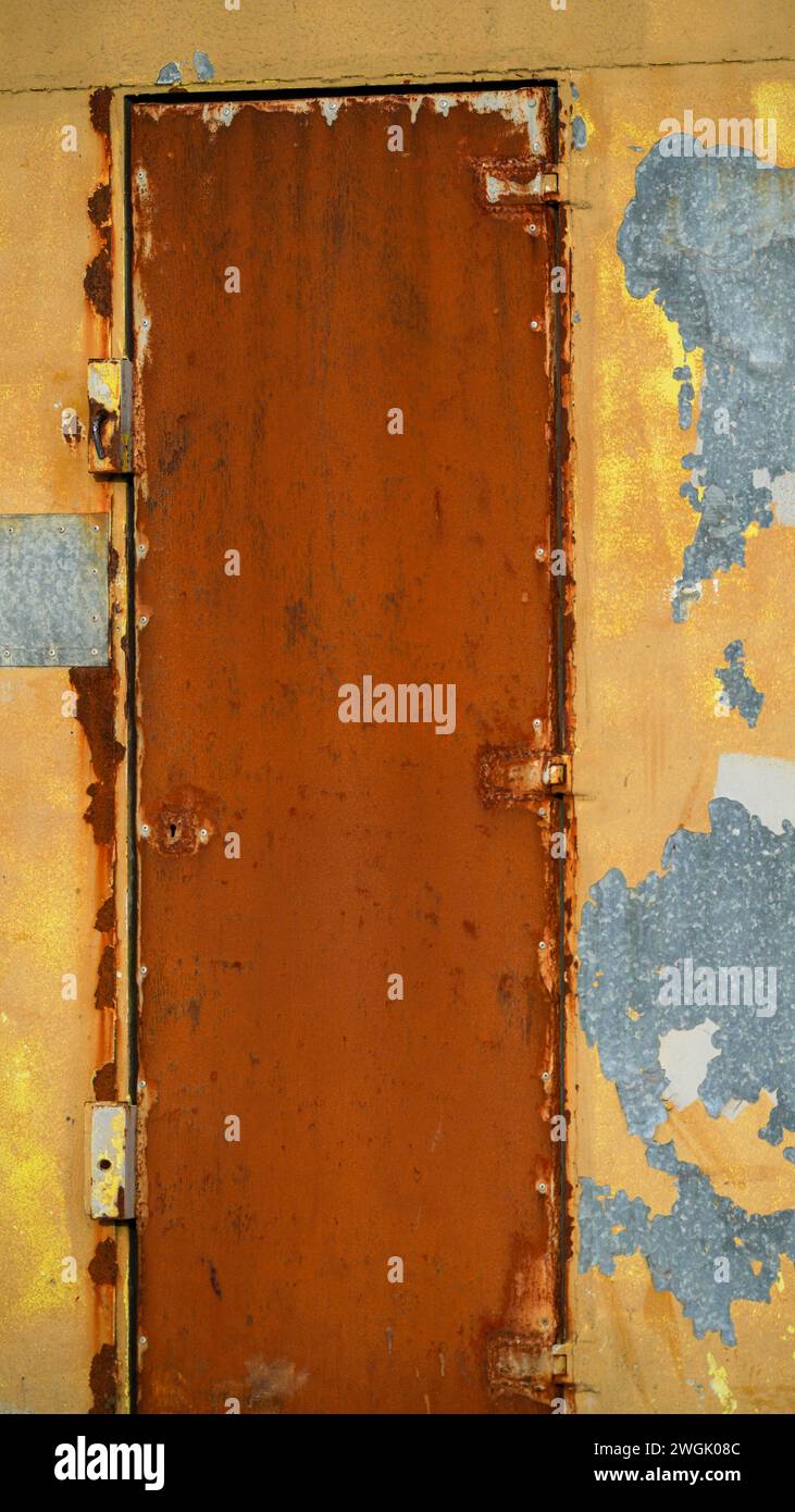 Large brightly painted yellow door on a lock-up in an industrial ...