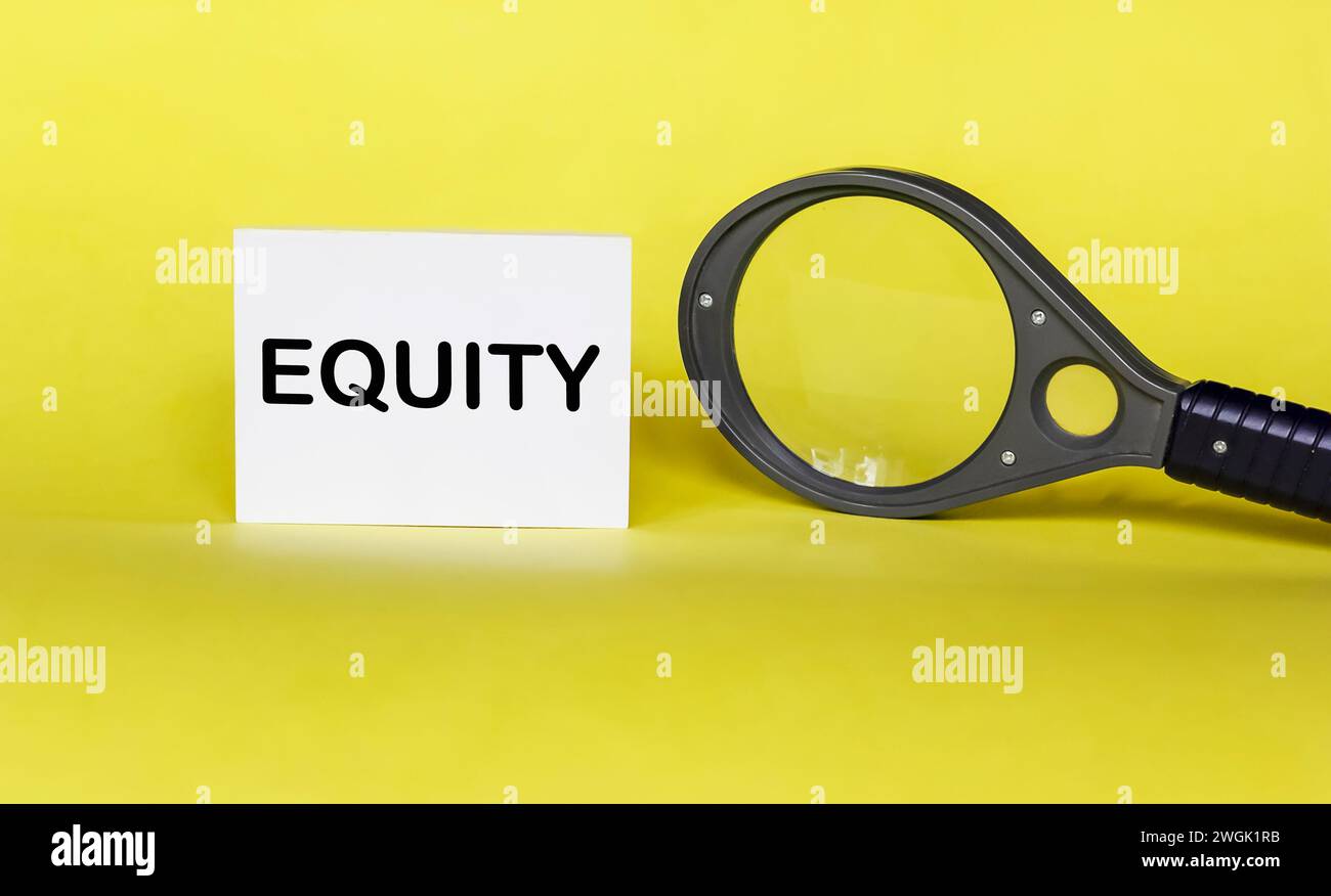 The word EQUITY written on a sticker on a yellow background with a ...