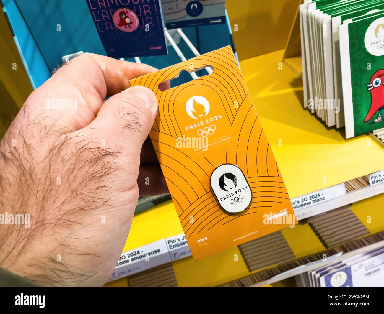 Paris, France - Jan 19, 2024: Hand picking up a Paris 2024 Olympic ...