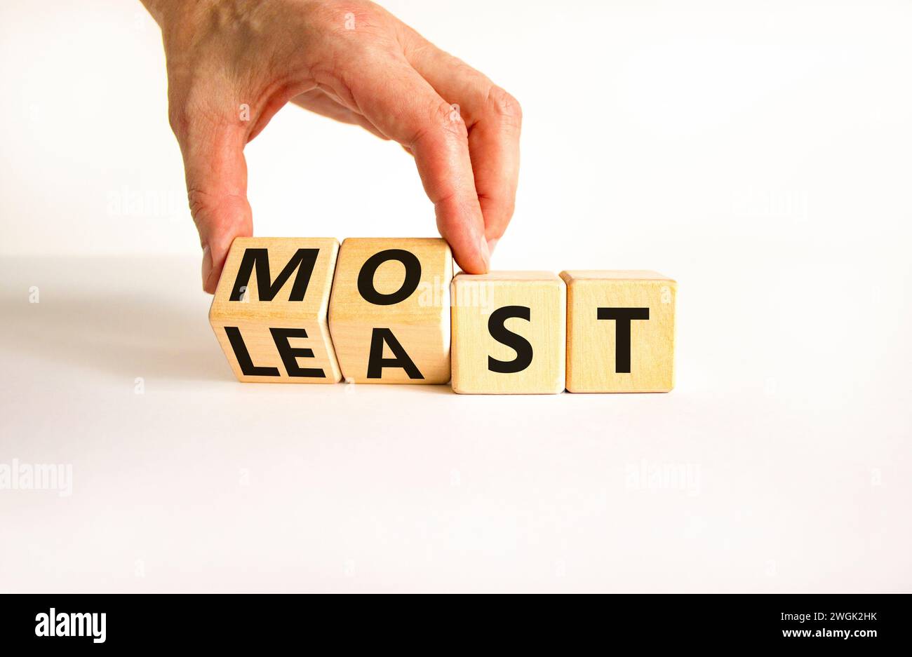 Most or least symbol. Businessman turns beautiful wooden cubes and ...