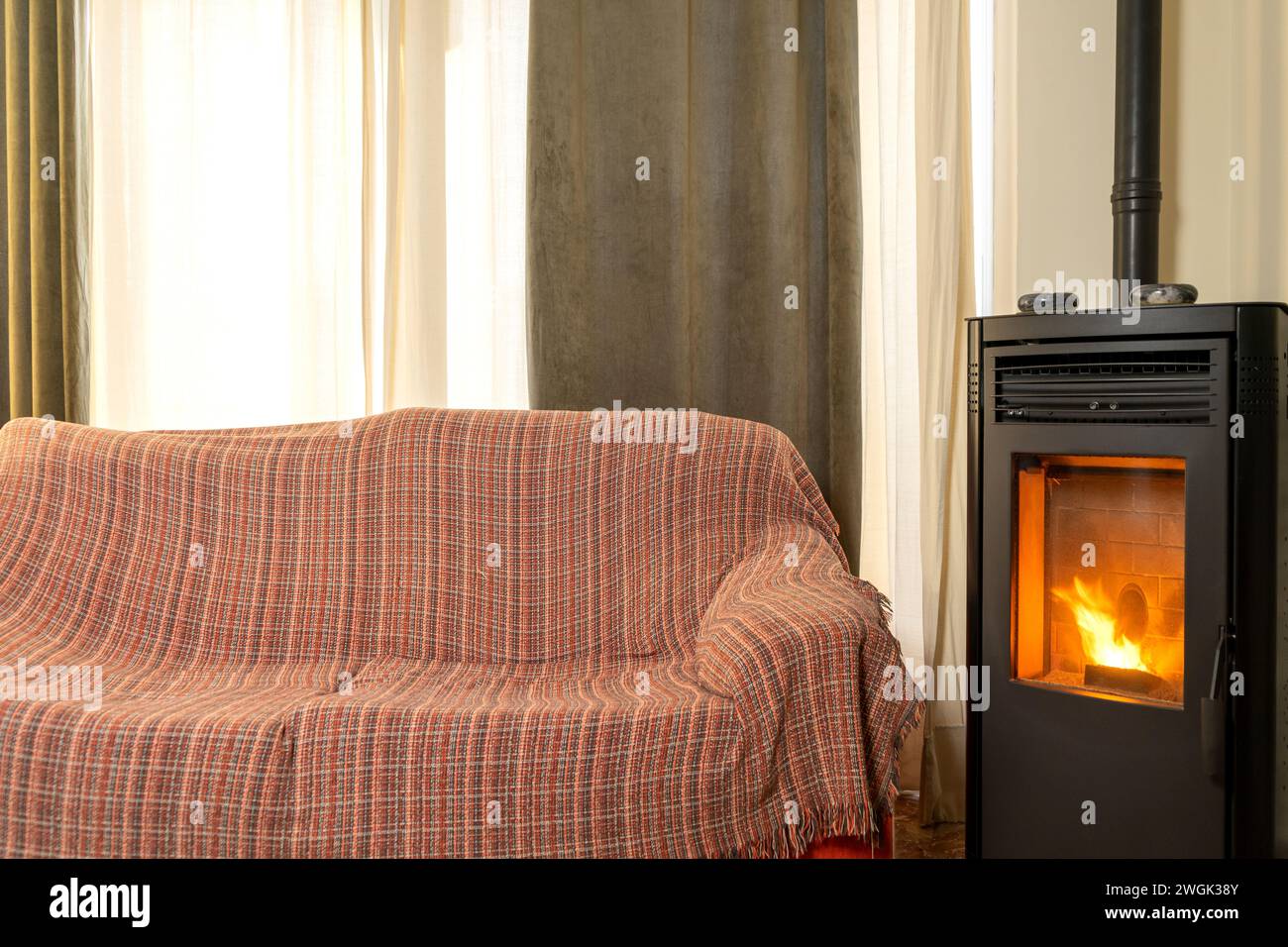 Living room with comfortable worn sofa with a cover covering it. Black ...