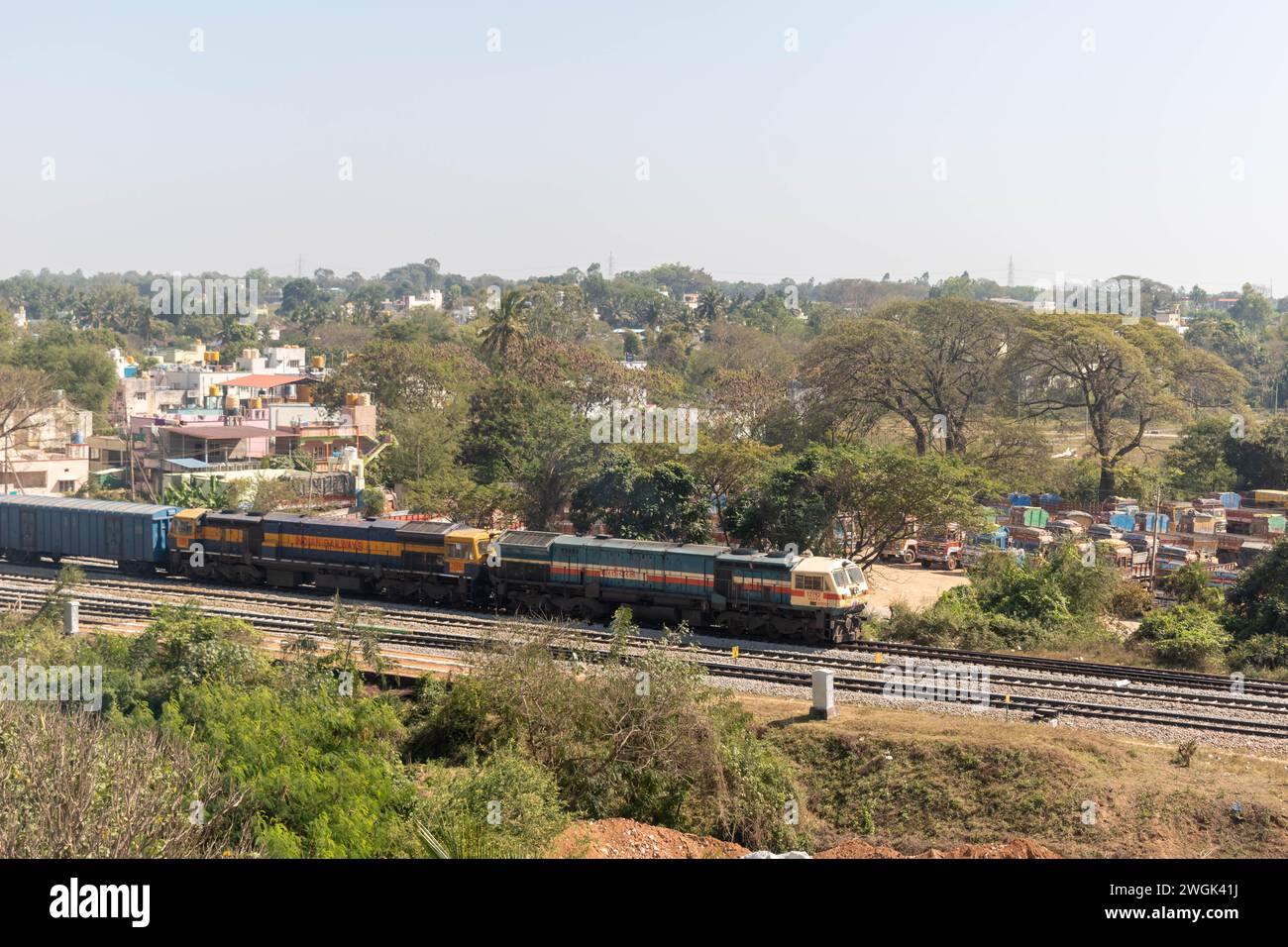 A colorful freight train moves along the tracks on the outskirts of a ...