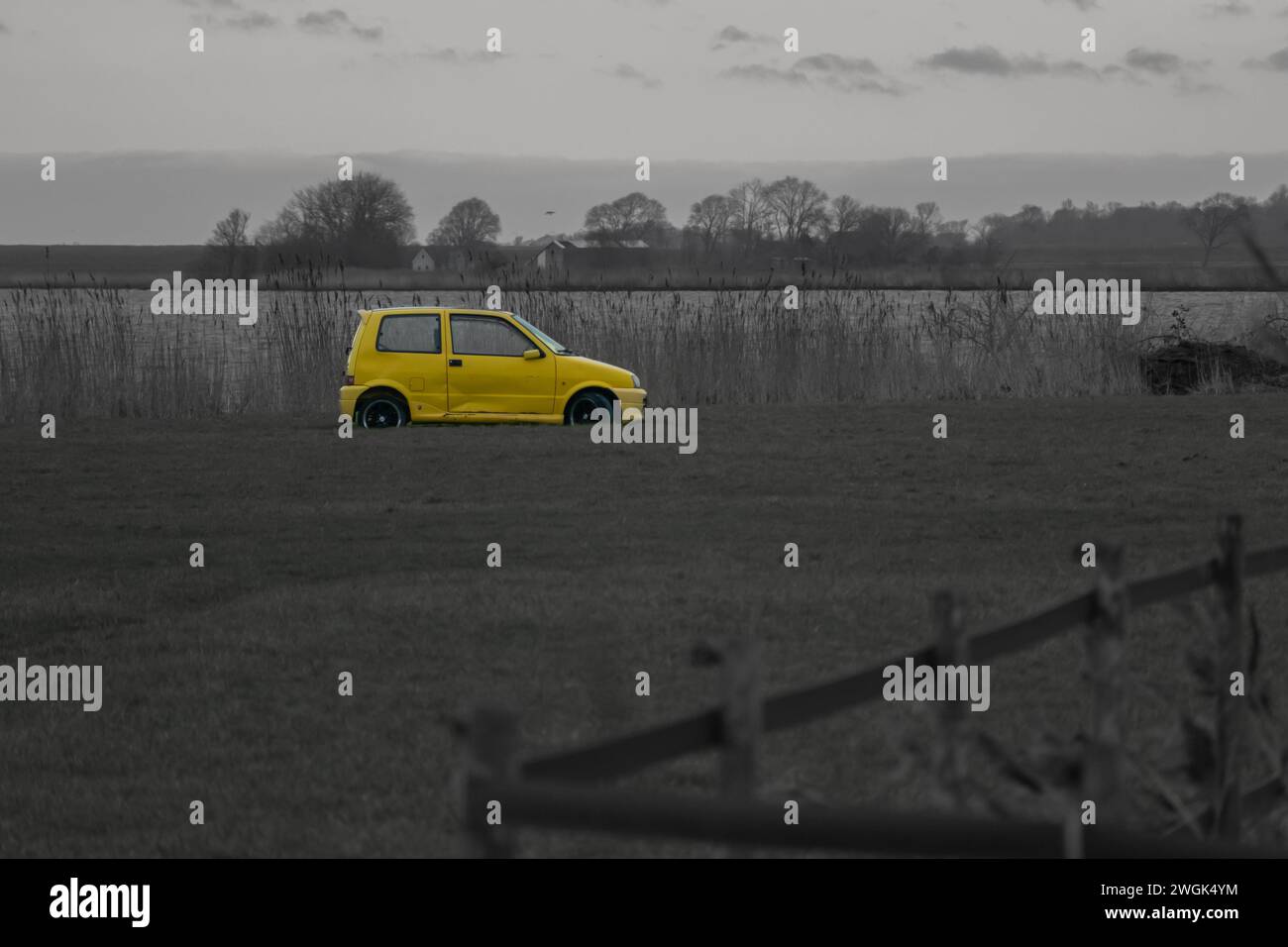 Yellow car in a meadow. By depicting the surroundings of the car in ...
