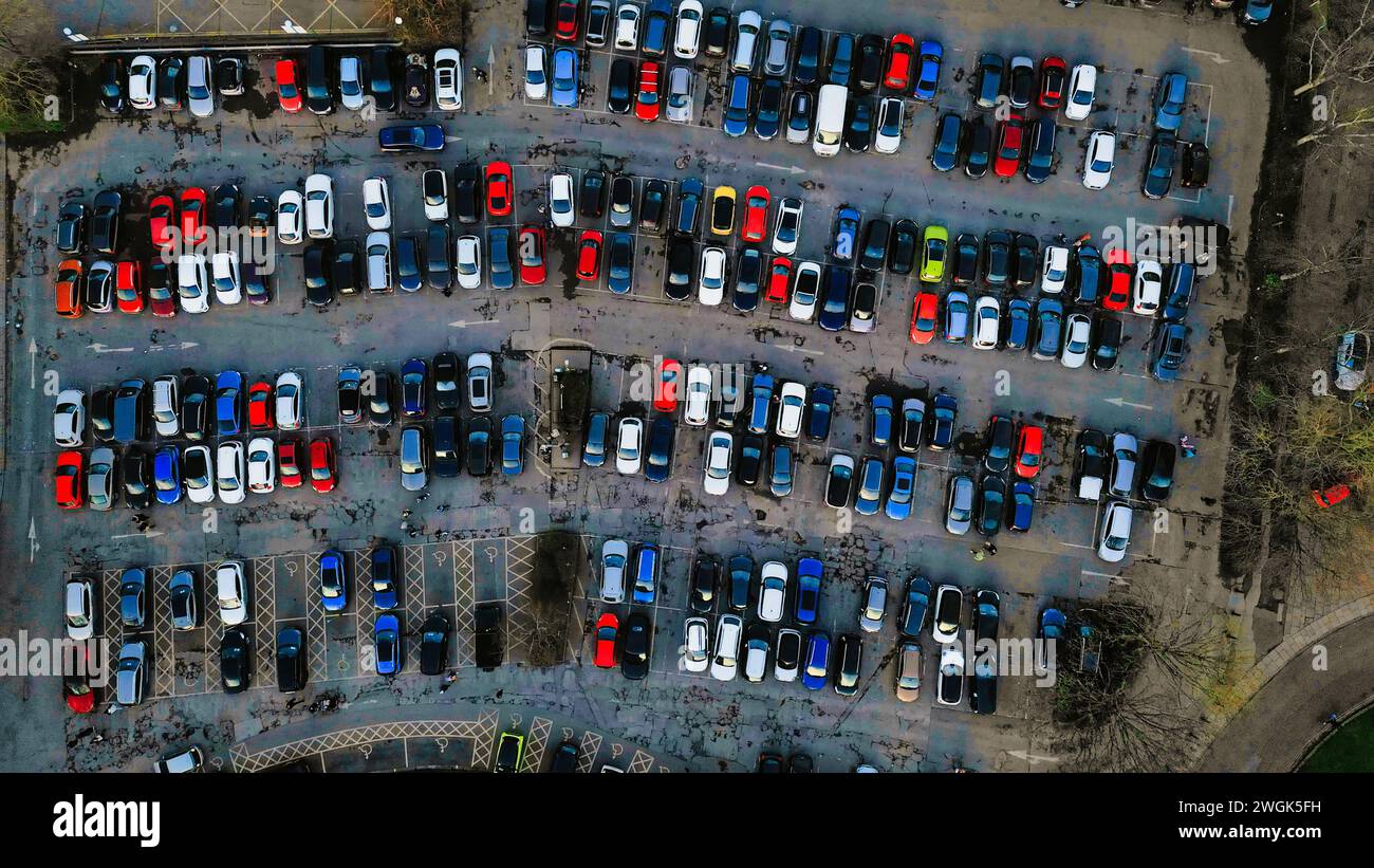 Aerial view of a crowded parking lot with various cars neatly parked in ...