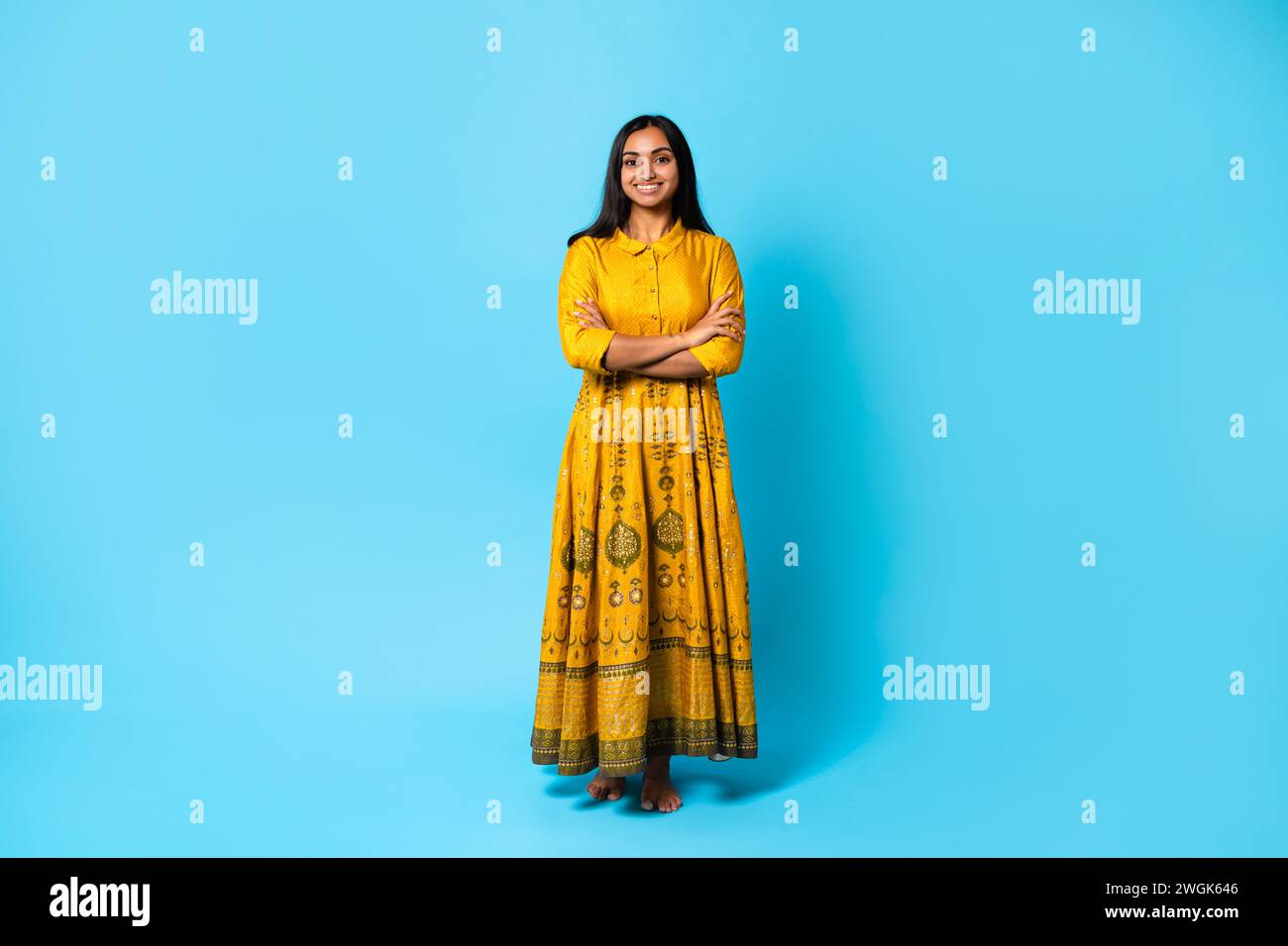 Smiling hindu lady wearing dress posing with folded arms, studio Stock ...