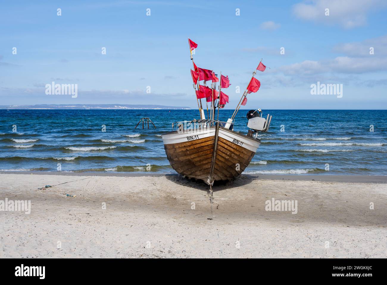 Ein Fischerboot am Strand von Binz auf Rügen mit roten Fahnen der ...