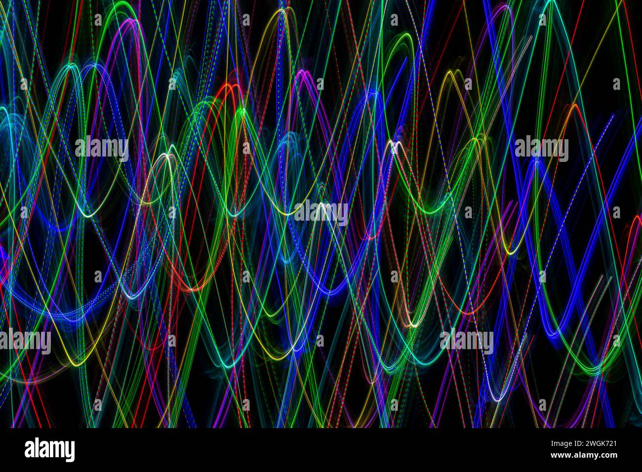 Multi-colored lines in the shape of waves on a black background. Long exposure photography Stock ...