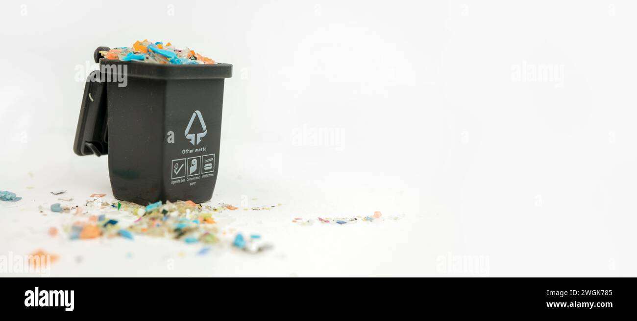 Macro shot of a mini plastic trash can full of micro plastics. Concept ...
